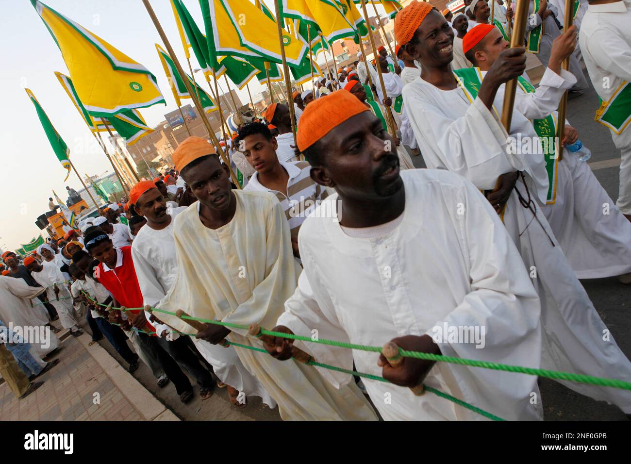 Sudanese Muslims use ropes to form a border of their parade during a ...