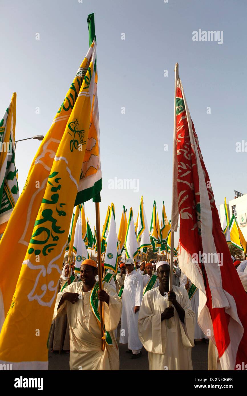 Sudanese Muslims raise colored flags during a parade to celebrate Sufi ...