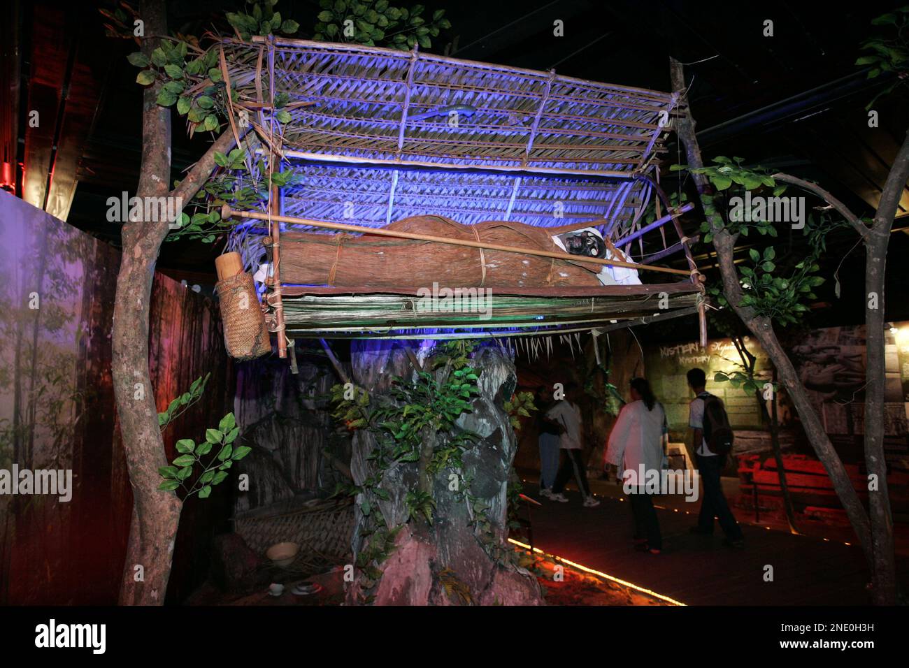 Visitors walk past a Bateq tribe burial platform on display during a ...