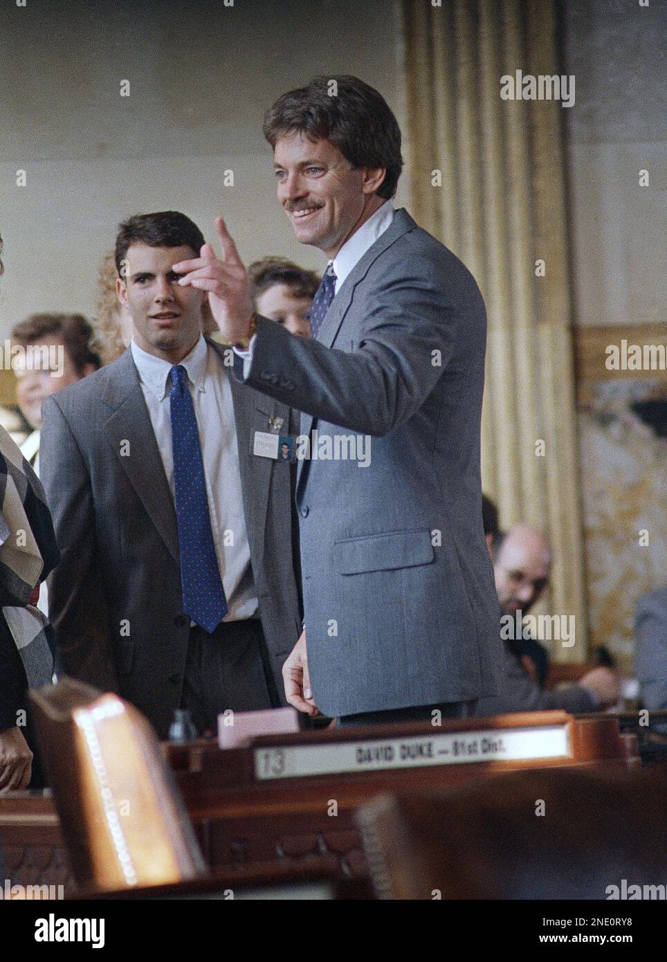 David Duke waves to the cameras as he stands at his desk on the floor ...