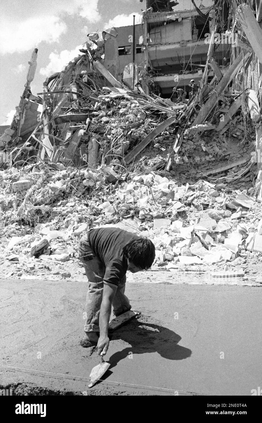 A worker smoothes a fresh concrete sidewalk on a Mexico City street in ...
