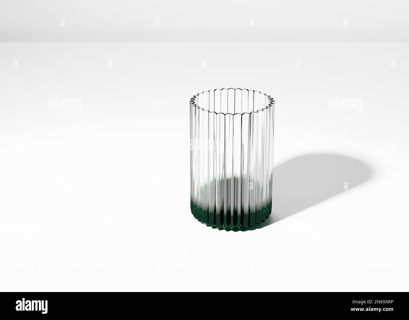 An Empty ribbed glass with colored bottom on empty white studio surface ...