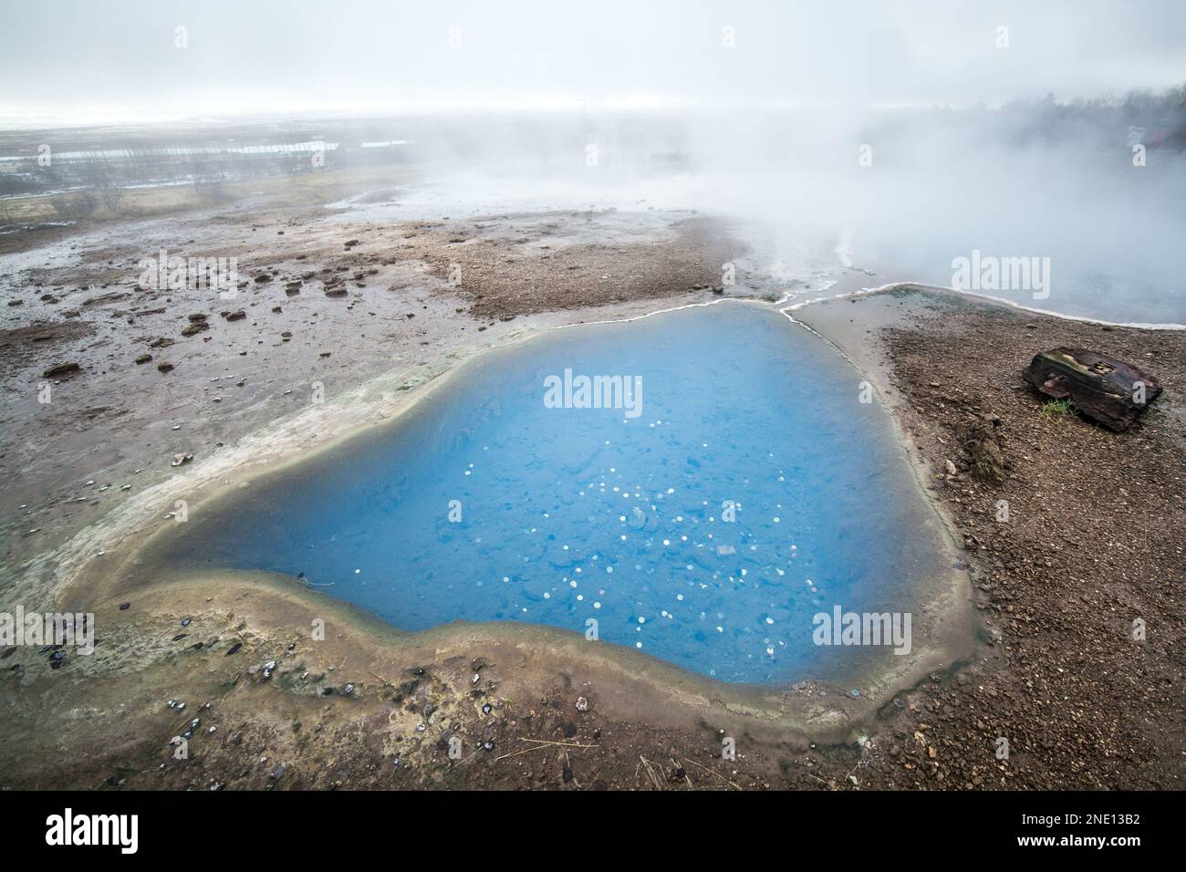An aerial view of blue geyser surrounded by rocks Stock Photo - Alamy