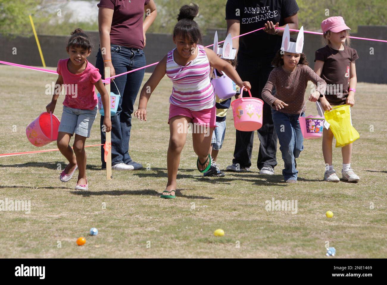 Kids run after and pick up eggs at the start of an Easter egg hunt at ...