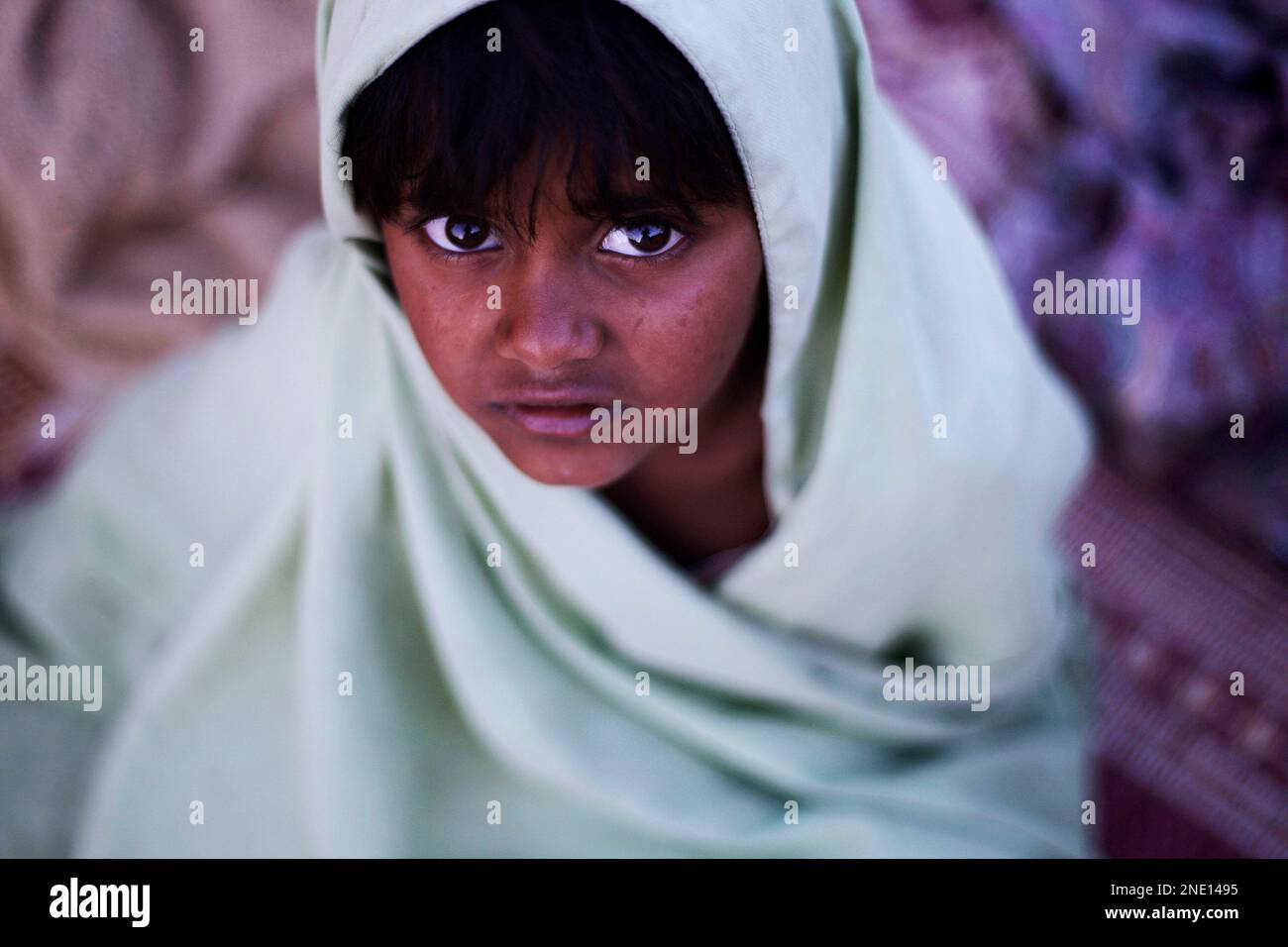 Pakistani Iqra Ismail , 6, looks up, during a daily class to learn how ...