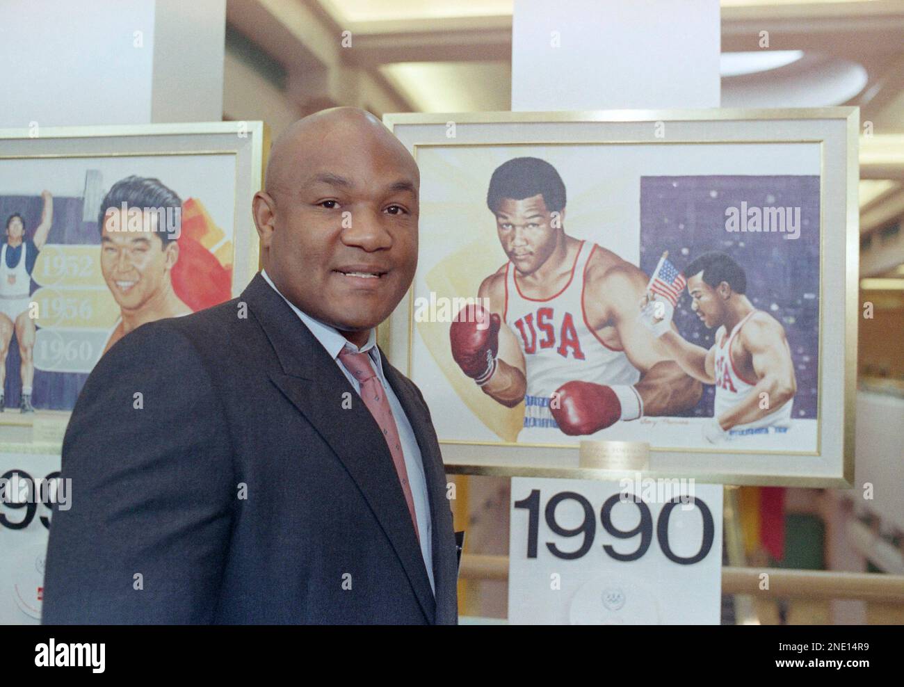 Boxer George Foreman posed by a painting of himself when he was at ...