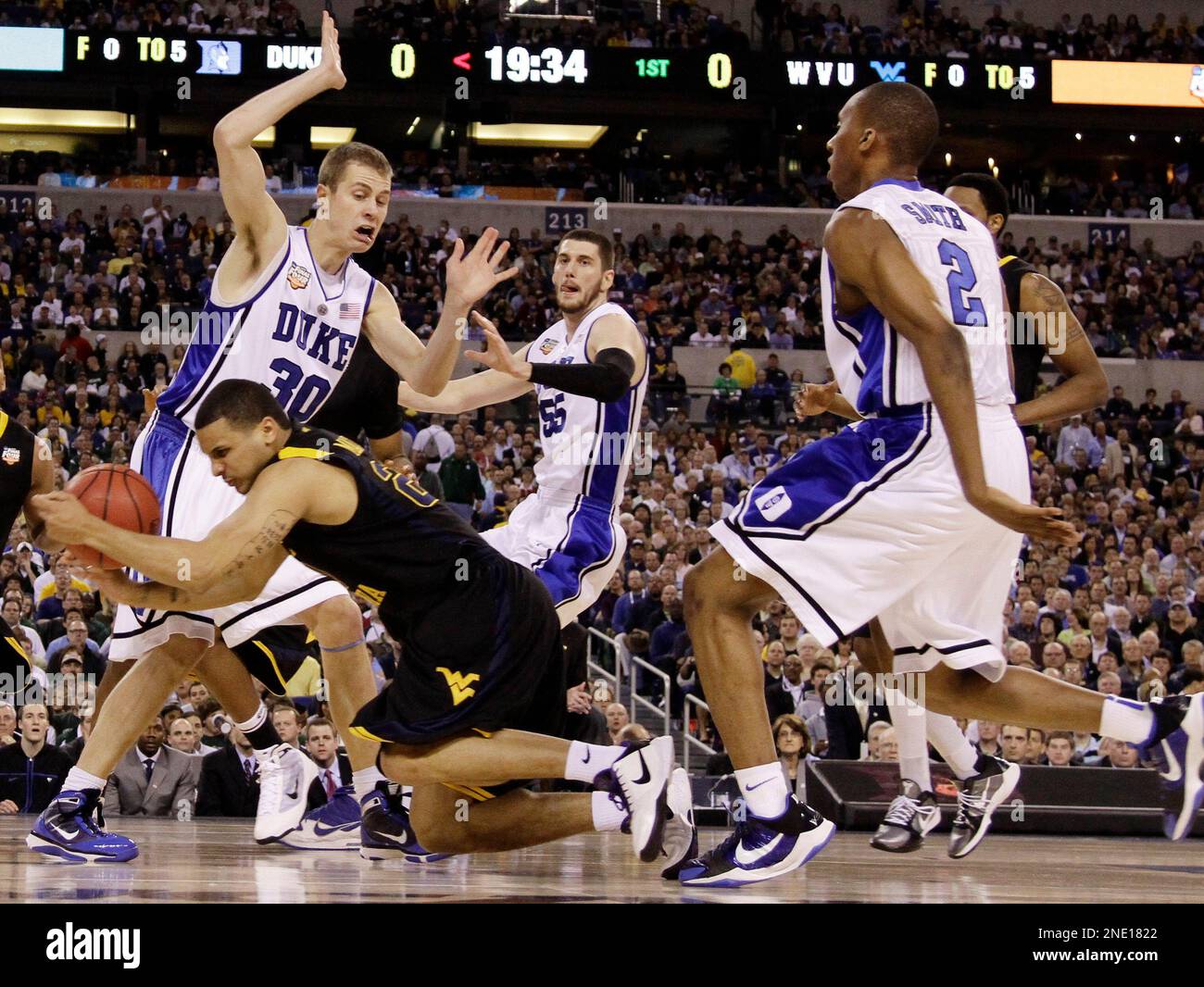 West Virginia's Joe Mazzulla (21) falls with the ball between Duke ...