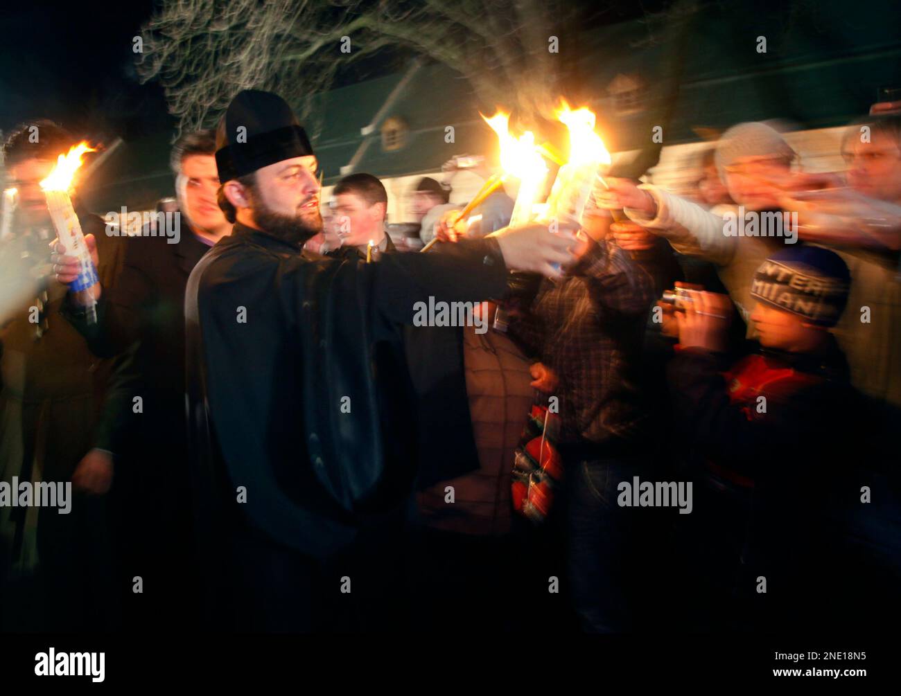 An Orthodox priest holds the Holy Fire brought from Jerusalem as ...