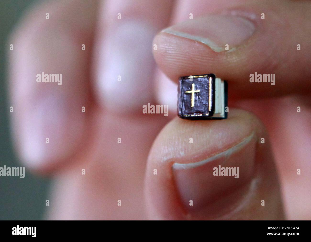 A woman shows a bible, claimed to be the world's smallest, displayed at ...