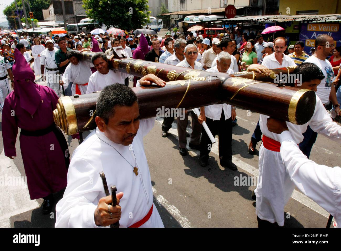 People carry a cross during a Holy Week procession in San Salvador ...