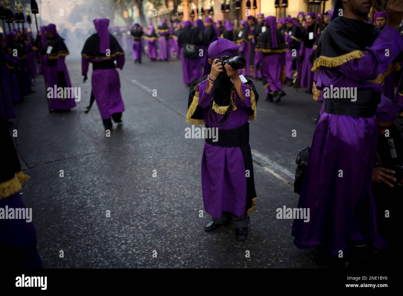 A boy takes pictures during a Holy Week procession in Guatemala City ...