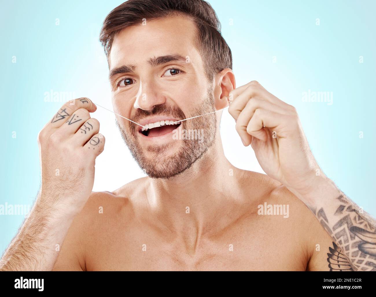 Portrait, face and man with dental floss in studio isolated on a blue background. Oral wellness ...