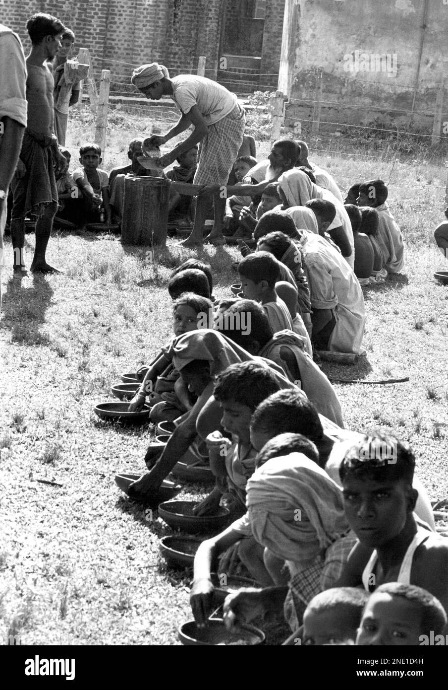 A Pakistan relief worker dishes out rice to give villagers of Bhola ...