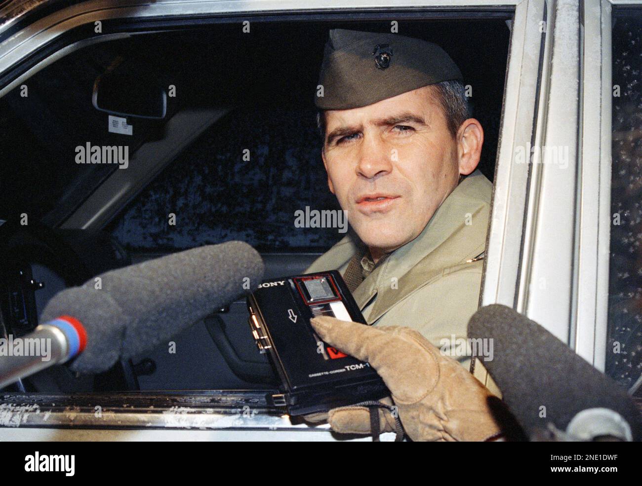 Marine Lt. Col. Oliver North, talks with reporters as he leaves his ...