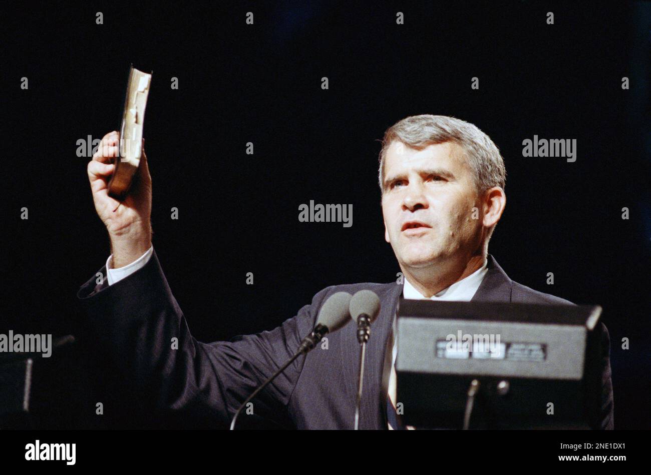 Oliver North holds up a copy of the bible to emphasize a point as he ...