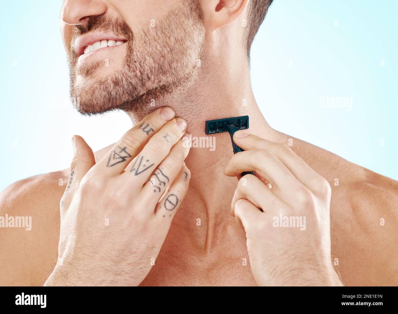 Hands, shave and beard with a man grooming in studio on a blue ...