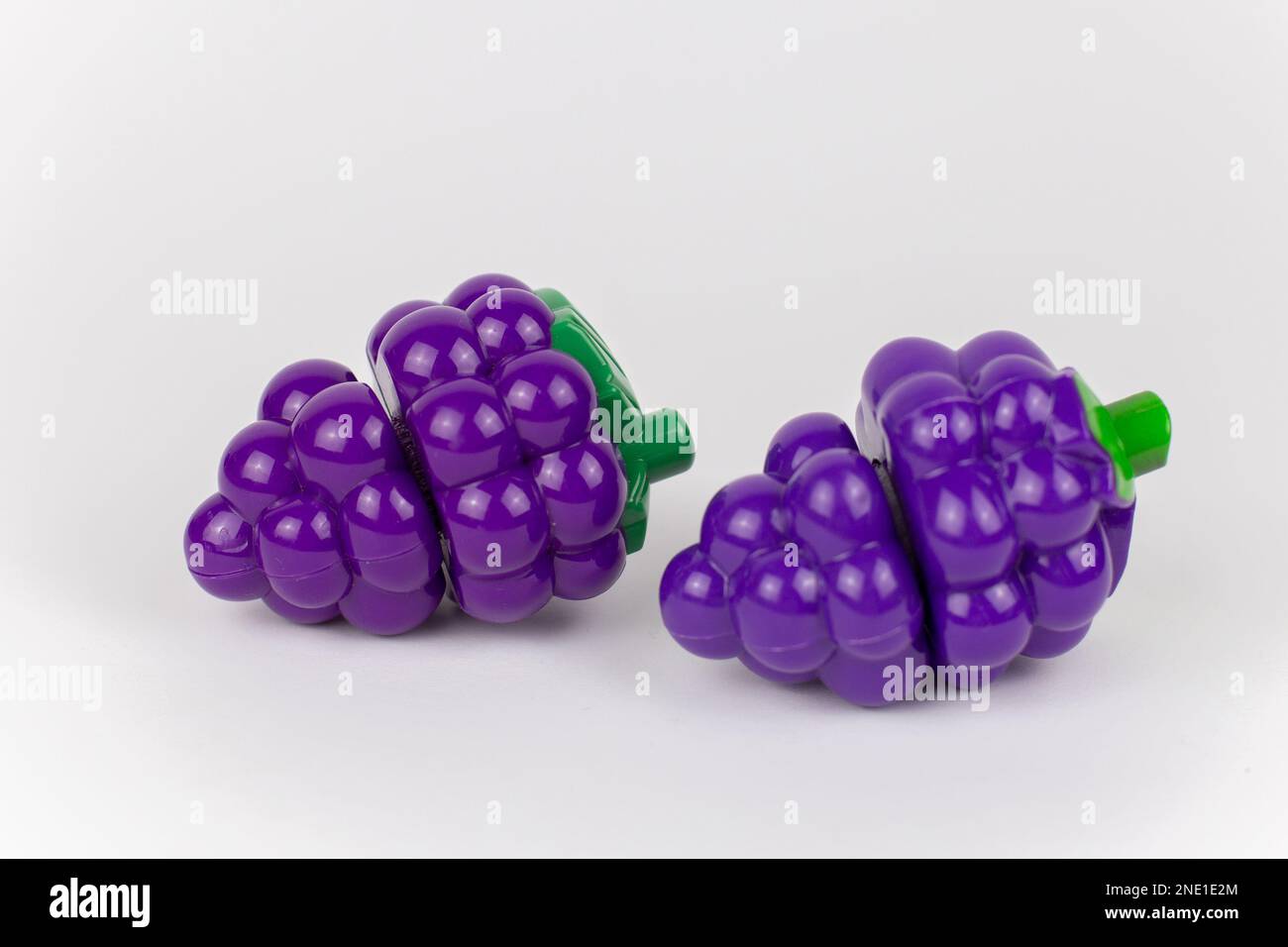a plastic toy grapes on a white background Stock Photo - Alamy