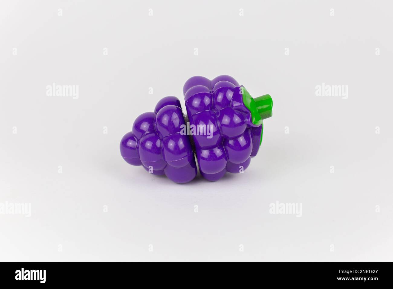 a plastic toy grapes on a white background Stock Photo - Alamy