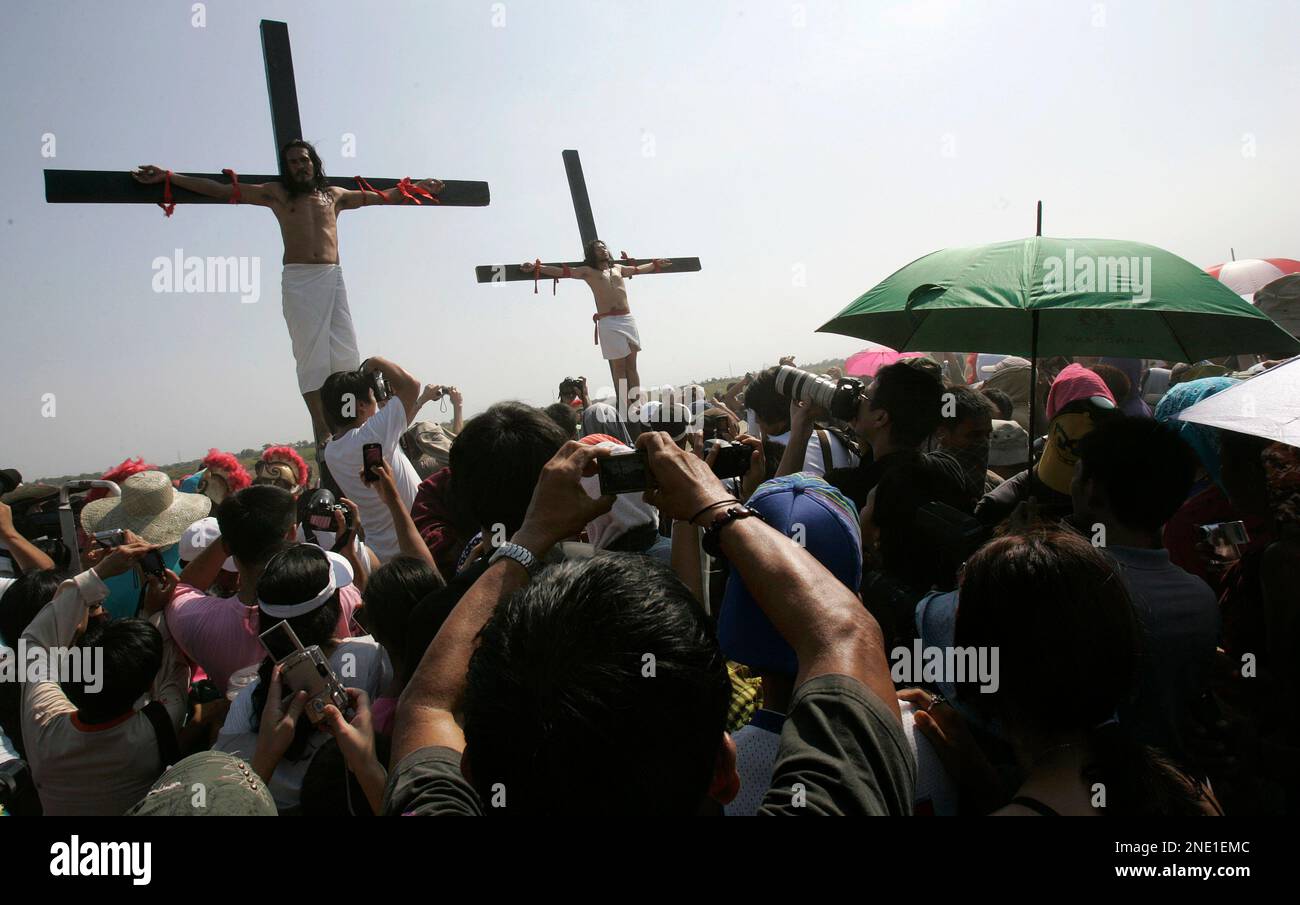 A crowd looks at Filipino penitents that were nailed to a cross during ...