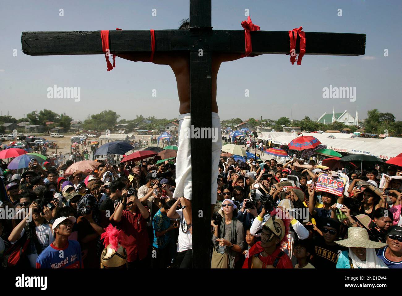 A crowd looks at a Filipino penitent nailed to a cross during yearly ...
