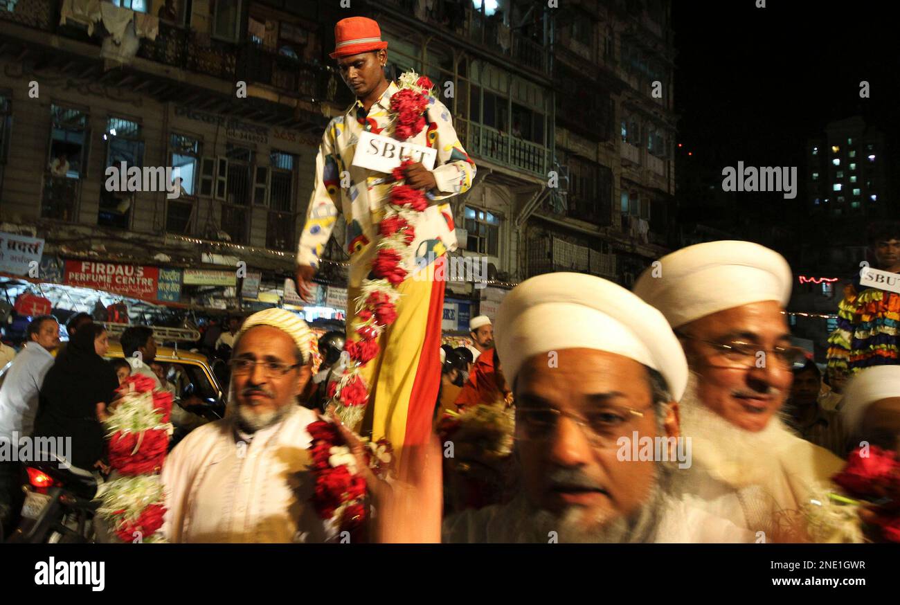 An Indian acrobat walks on a pair of wooden logs during a procession of ...
