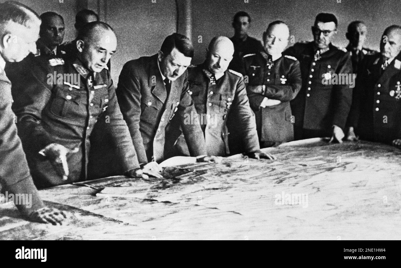 German Chancellor Adolf Hitler studying war maps surrounded by his ...