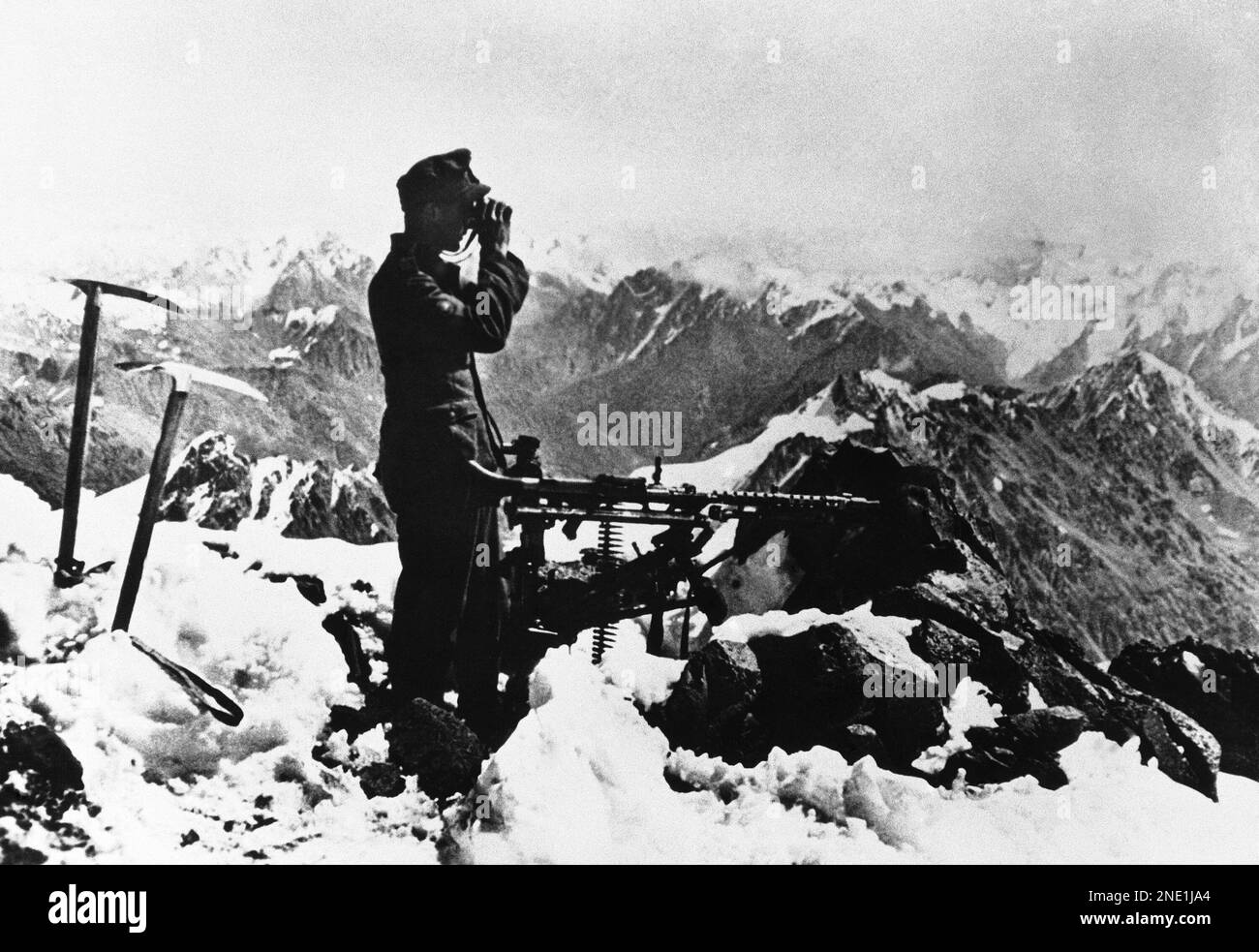 A sentry looks through binoculars at the highest machine gun position ...