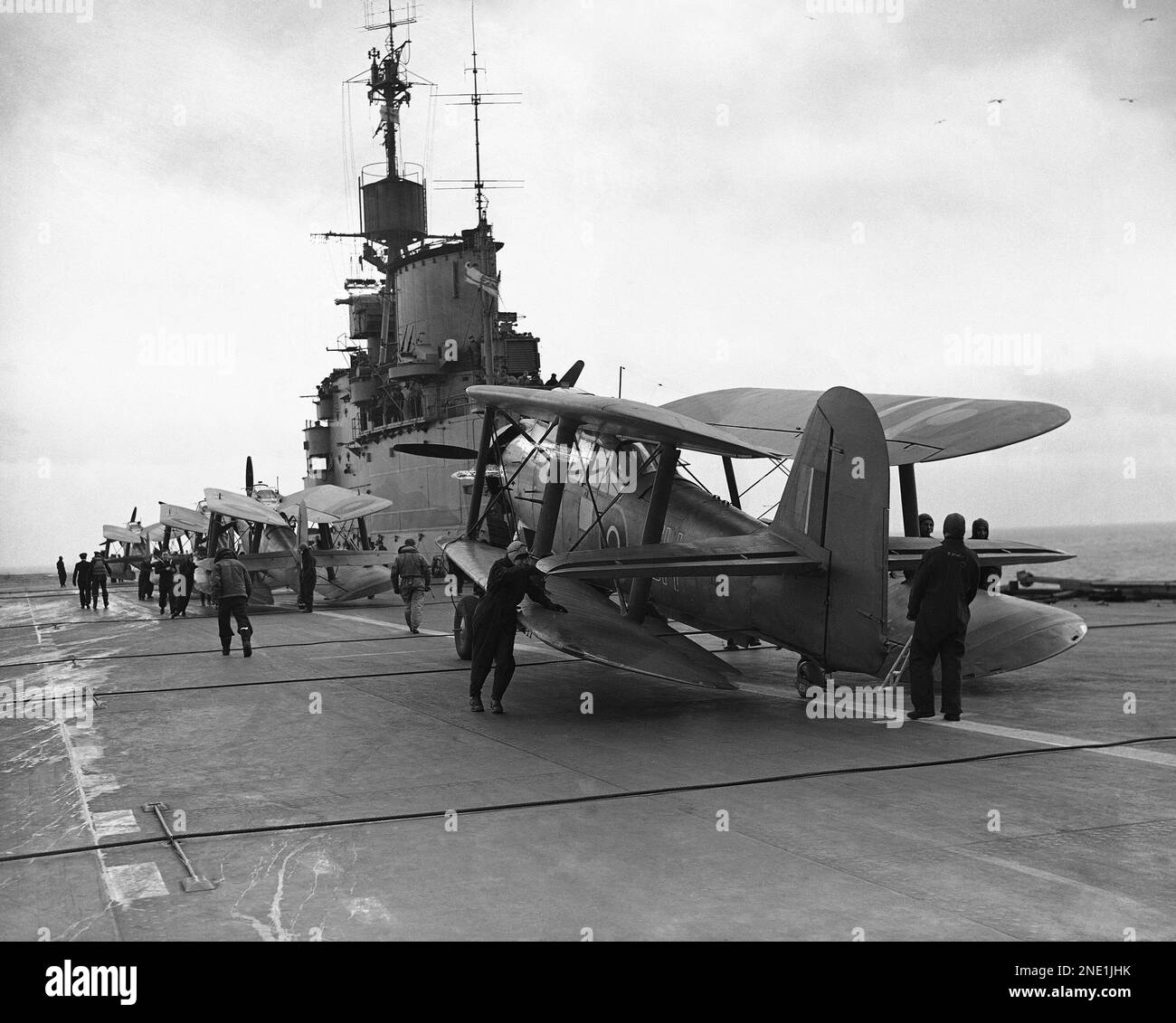 An Albacore plane with its wings folded back is brought onto the deck ...