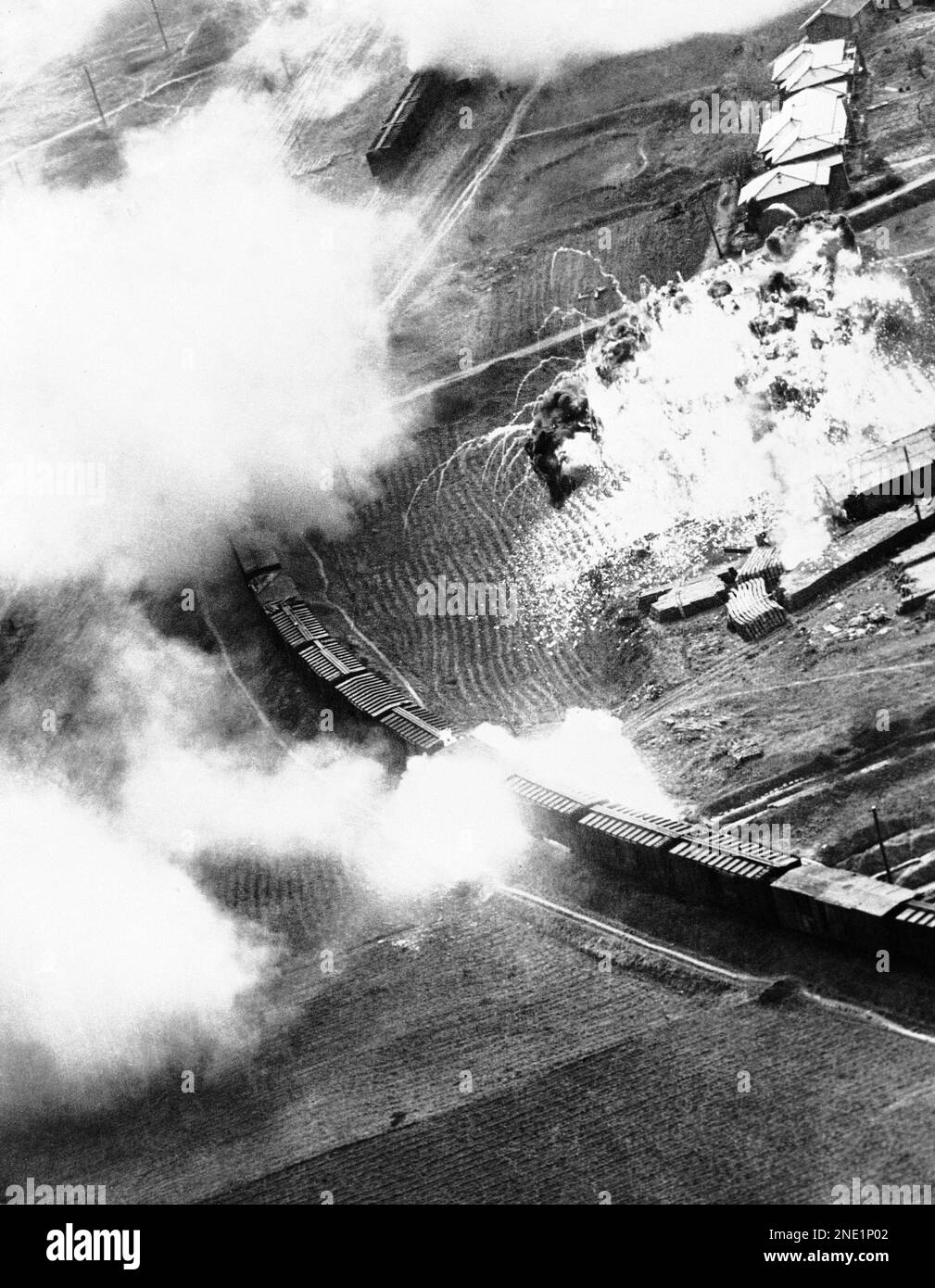 While loaded enemy freight cars burn following direct rocket hit, a ...
