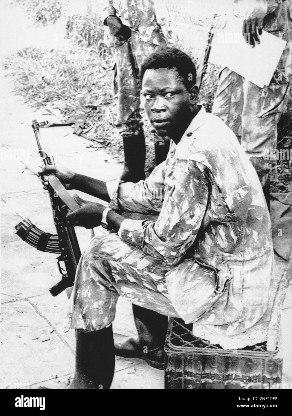 A Ugandan soldier holding a Soviet-designed AK-47 assault rifle, sits ...