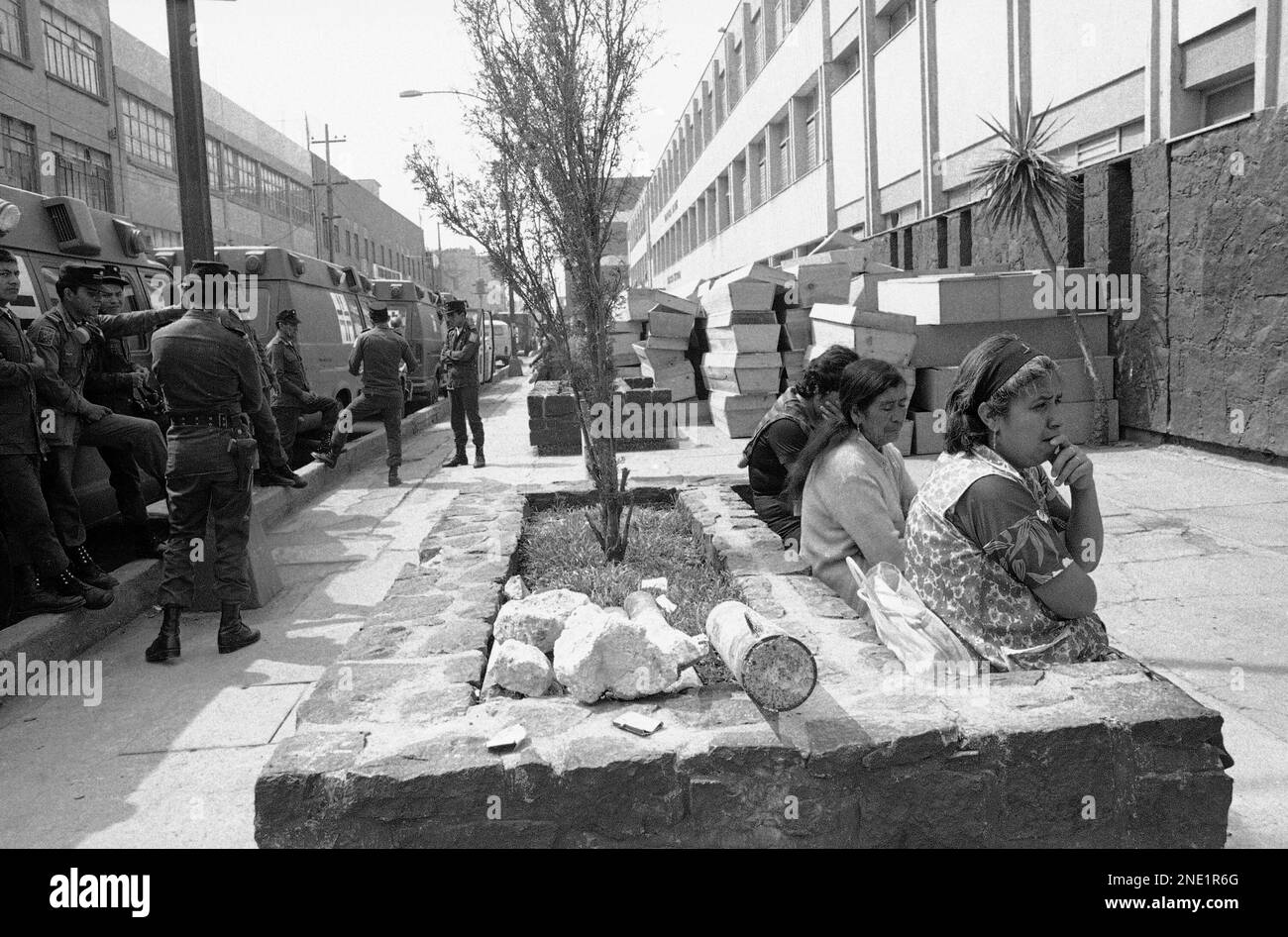 With coffins stacked high behind them, three women wait outside Mexico ...