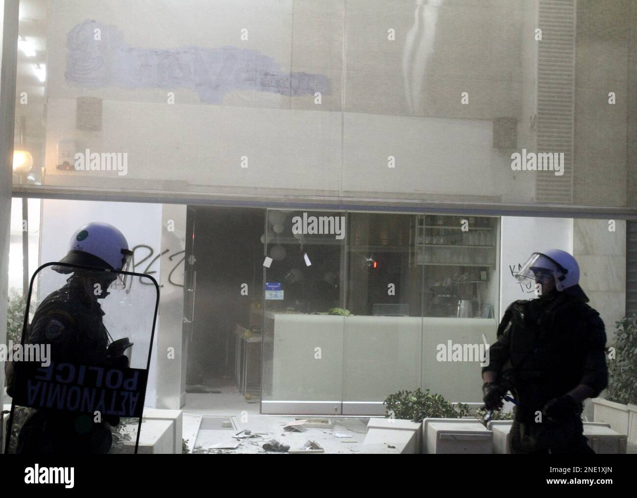 Riot policemen stand outside a shop damaged during a demonstration in ...