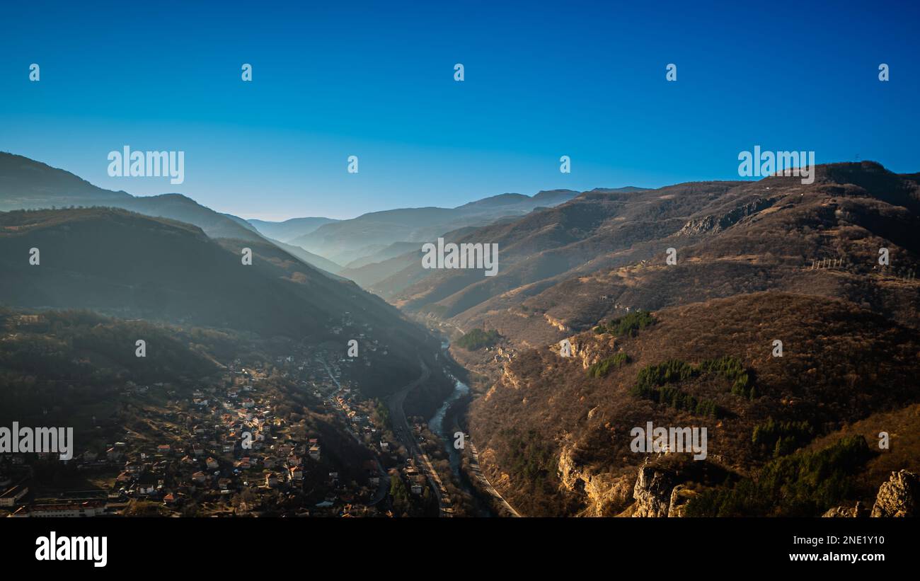 Aerial view of a small rural town nestled between hills, situated on ...