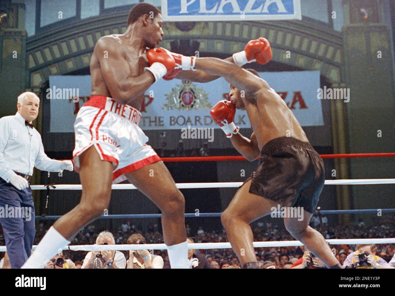 Heavyweight champion Mike Tyson takes a swing at challenger Frank Bruno ...