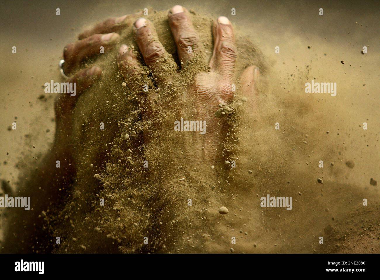 A traditional Indian wrestler smears mud on himself during a practice ...