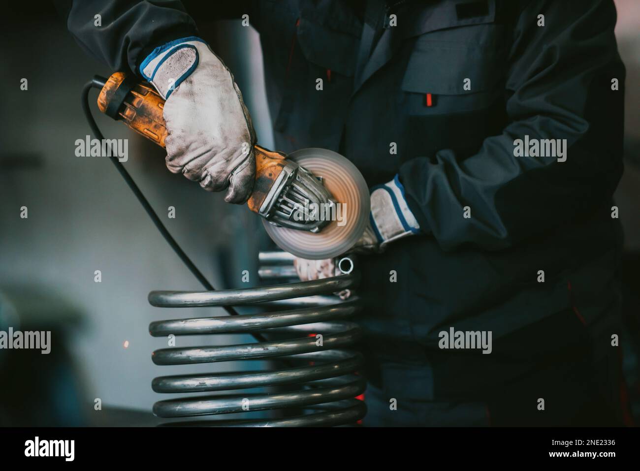 Locksmith in special clothes and goggles works in production. Metal ...