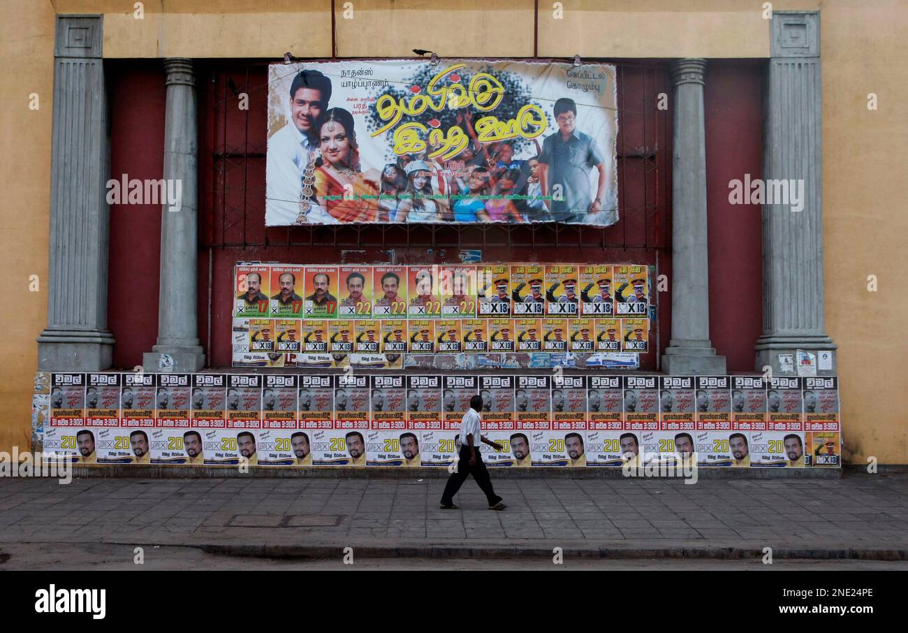 A Sri Lankan man walks past election propaganda posters outside a film ...
