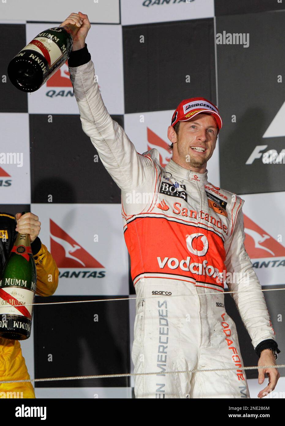 McLaren Formula One driver Jenson Button of Britain holds his champagne ...