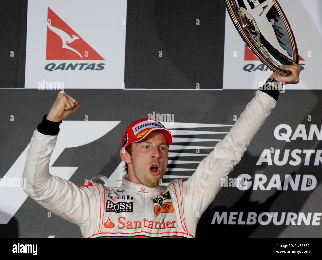 McLaren Formula One driver Jenson Button of Britain holds his trophy ...