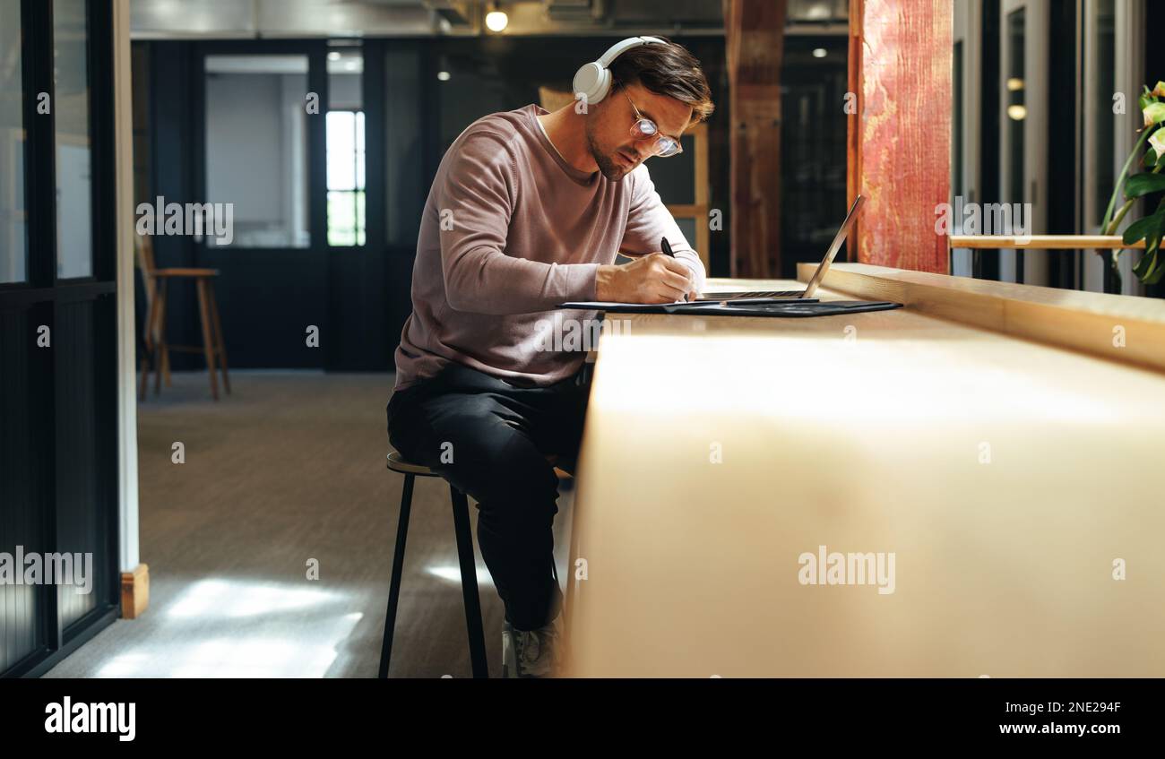 Professional web designer writing his progress in a clipboard. business ...