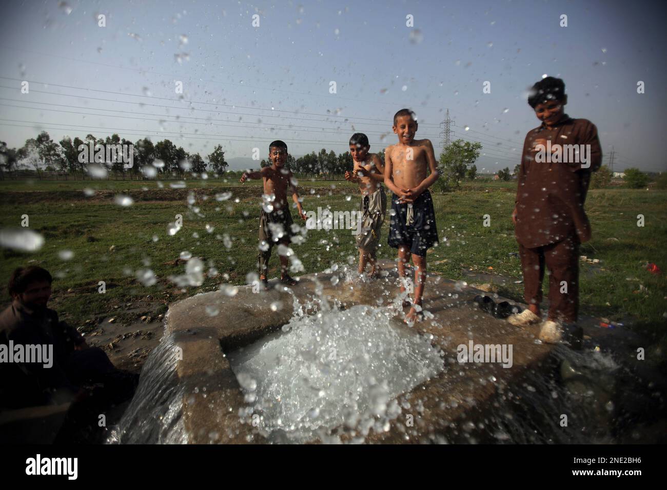 Pakistani boys jump in a water reservoir to cool off as the temperature ...