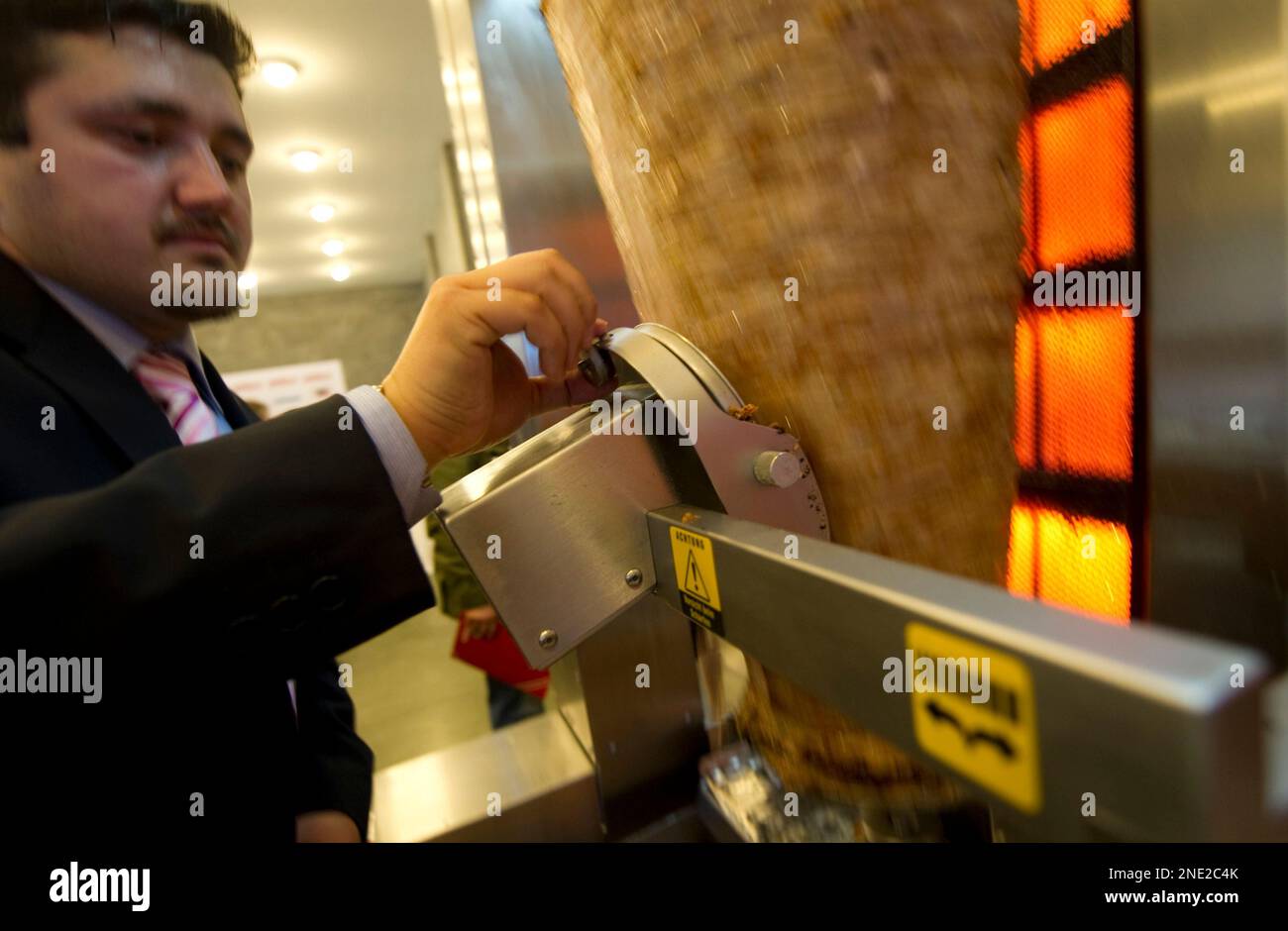 Turkish Mustafa Yuceer adjusts the automatic knife of a doner kebab ...