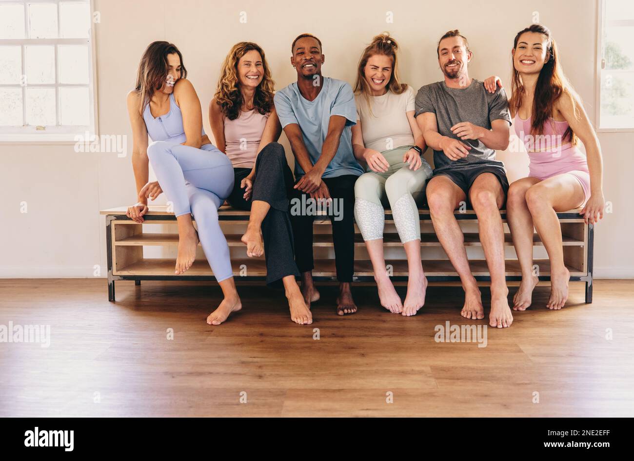 Group of diverse people smiling happily while sitting together in a ...