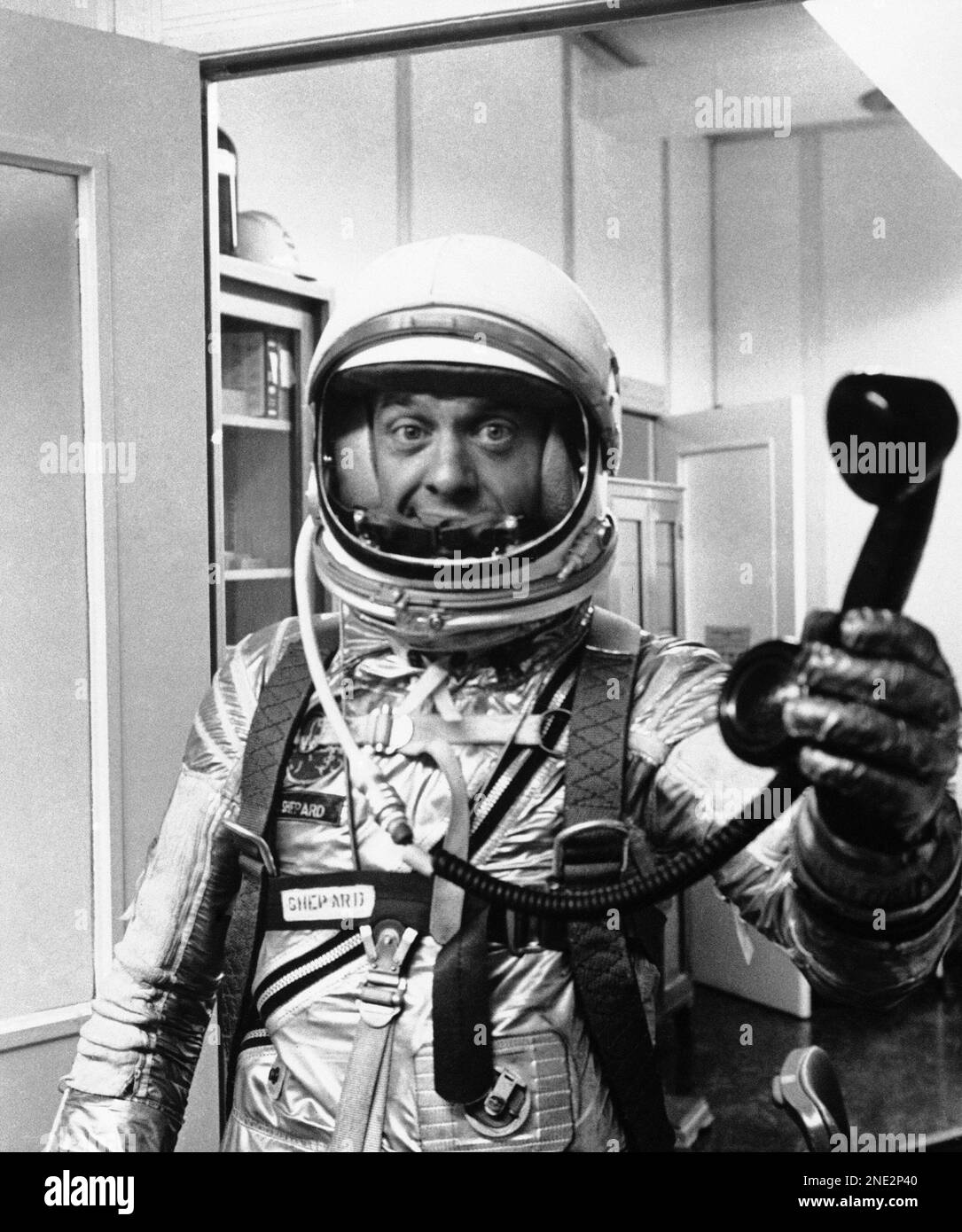 Alan Shepard, in his space suit makes last minute preparations for his ...