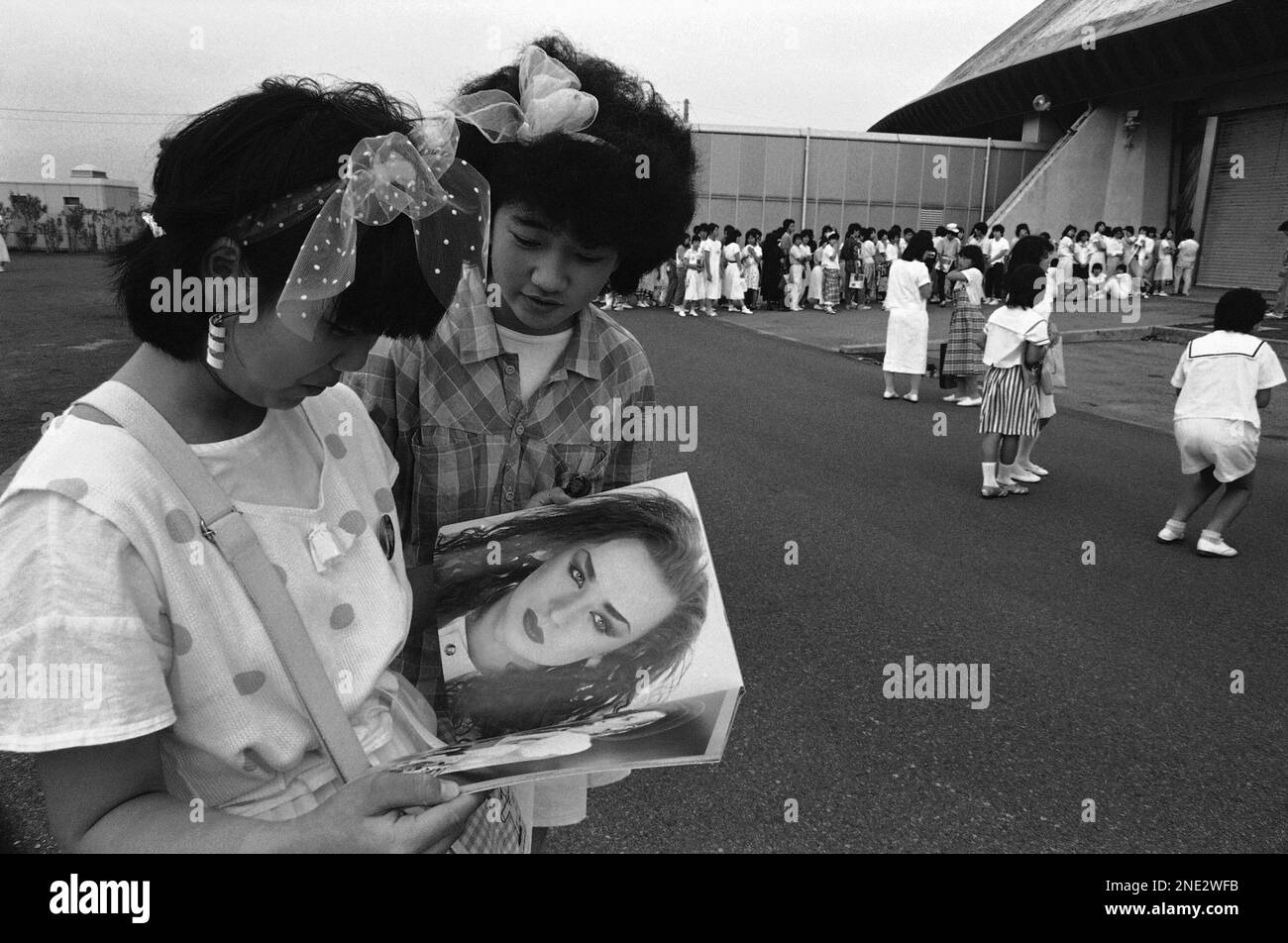 Young Japanese pop music fans look at portraits of British pop singer ...