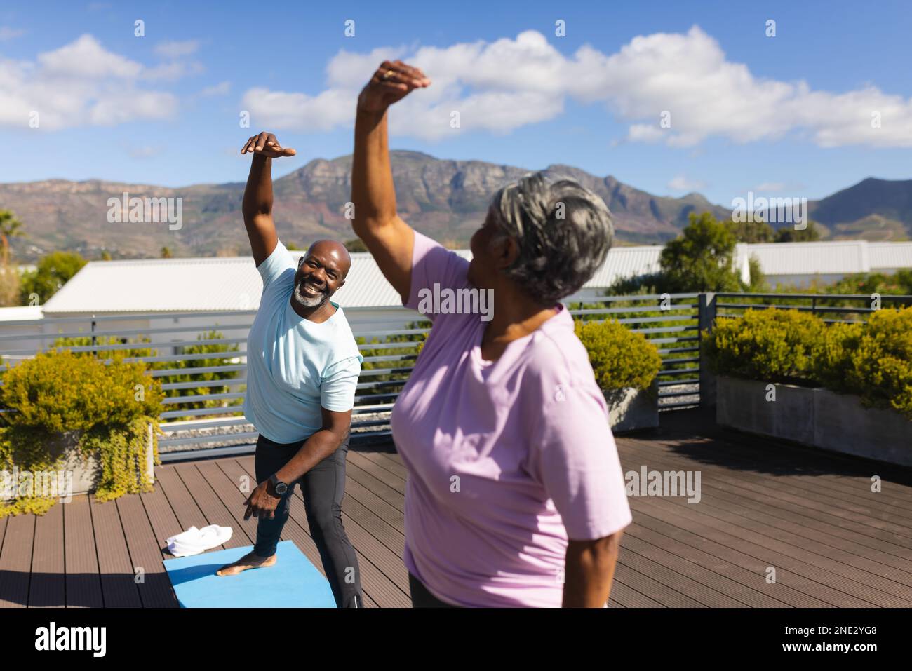 African american senior couple performing stretching exercise on the ...
