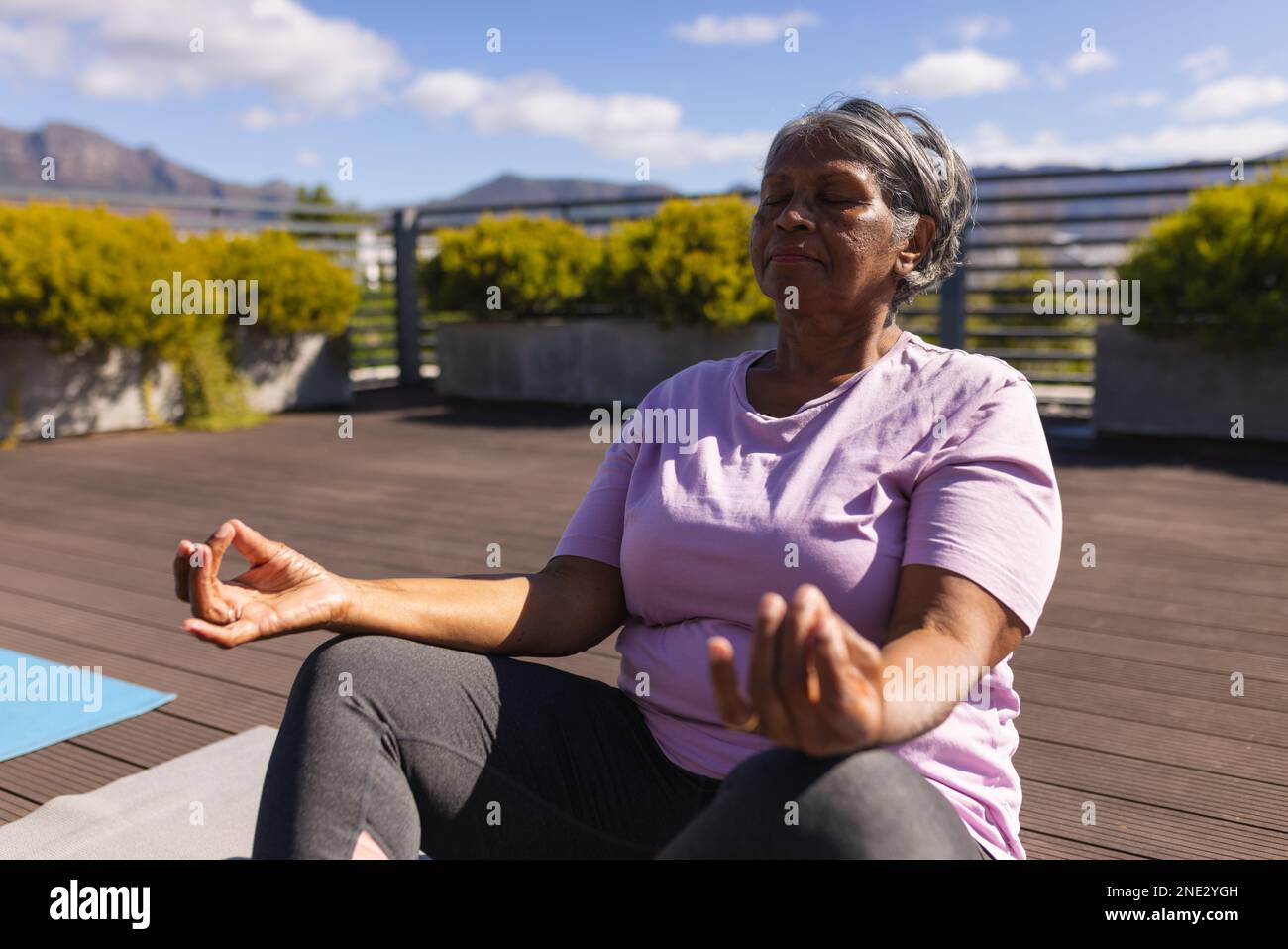 African american senior woman practicing yoga and meditating on the ...