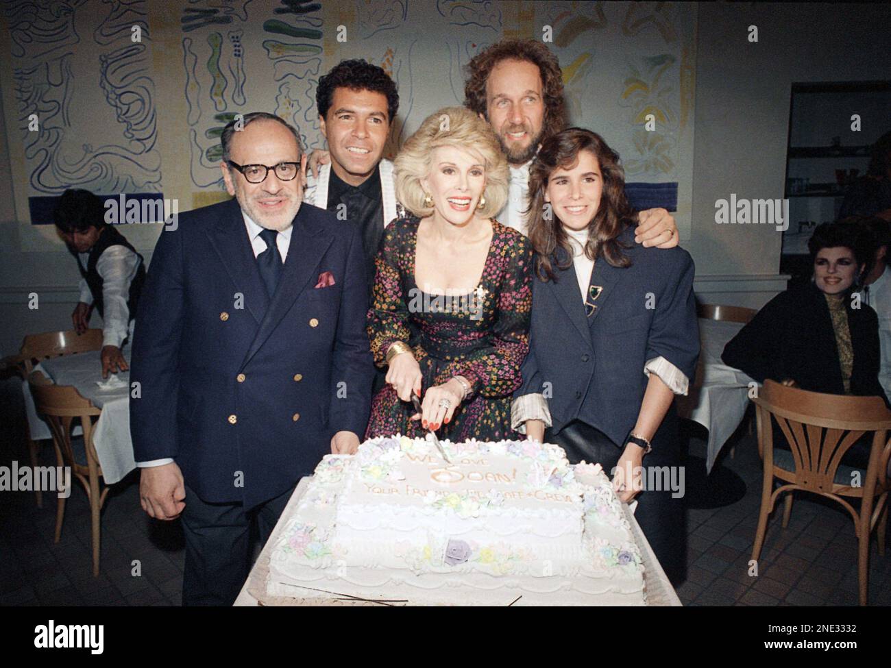 Comic Joan Rivers, center, cut a cake presented by her staff and crew ...
