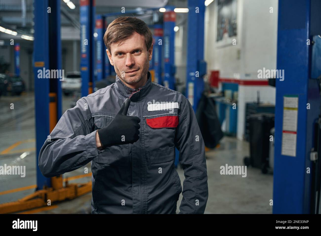Mechanic in overalls standing in the workshop Stock Photo - Alamy