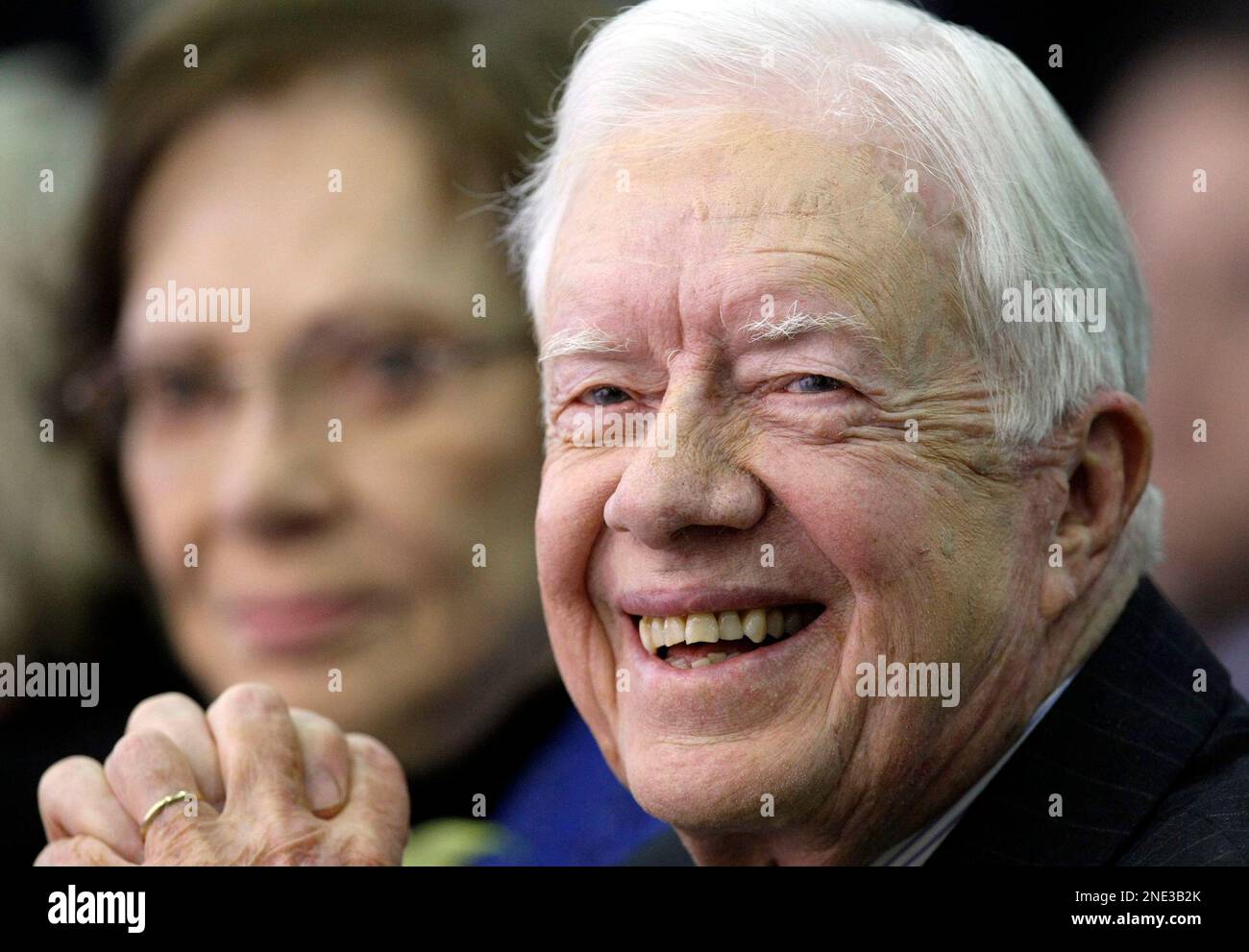 Former U.S. President Jimmy Carter smiles as his wife Rosalynn, rear ...